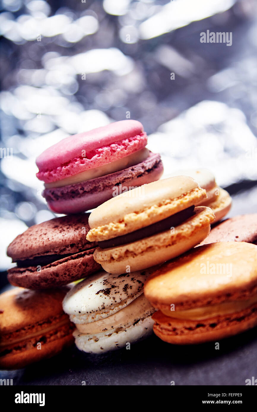 Macaroons on a black slate with a silver background, different colors ...