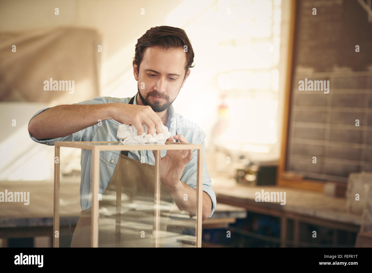 Craftsman applying the final touches to his carpentry project that he ...
