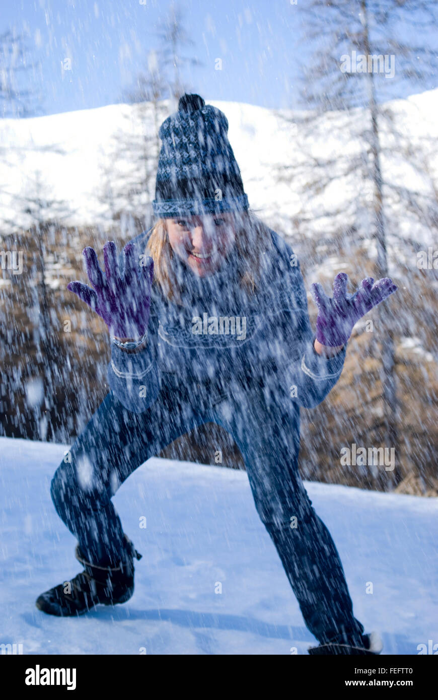 Playful woman throwing snow Stock Photo - Alamy