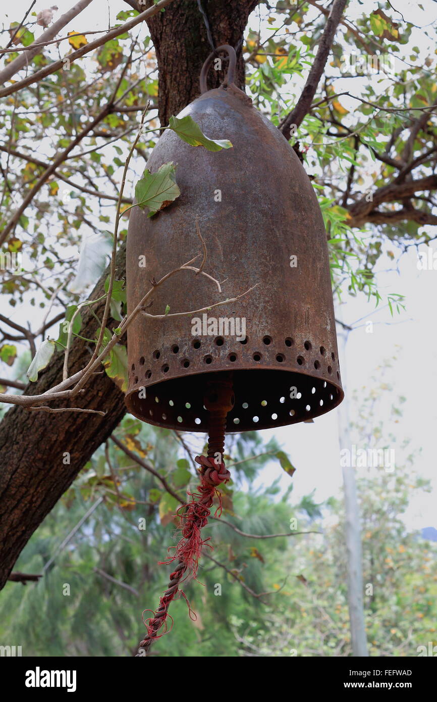 Rusty iron bell hanging from tree inside the compound of Gebriel Bete ...