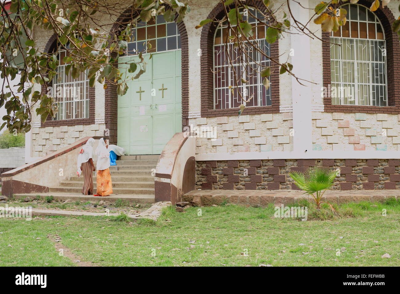 Faithful women-base of stairway leading to closed gate of Bete Gebriel ...