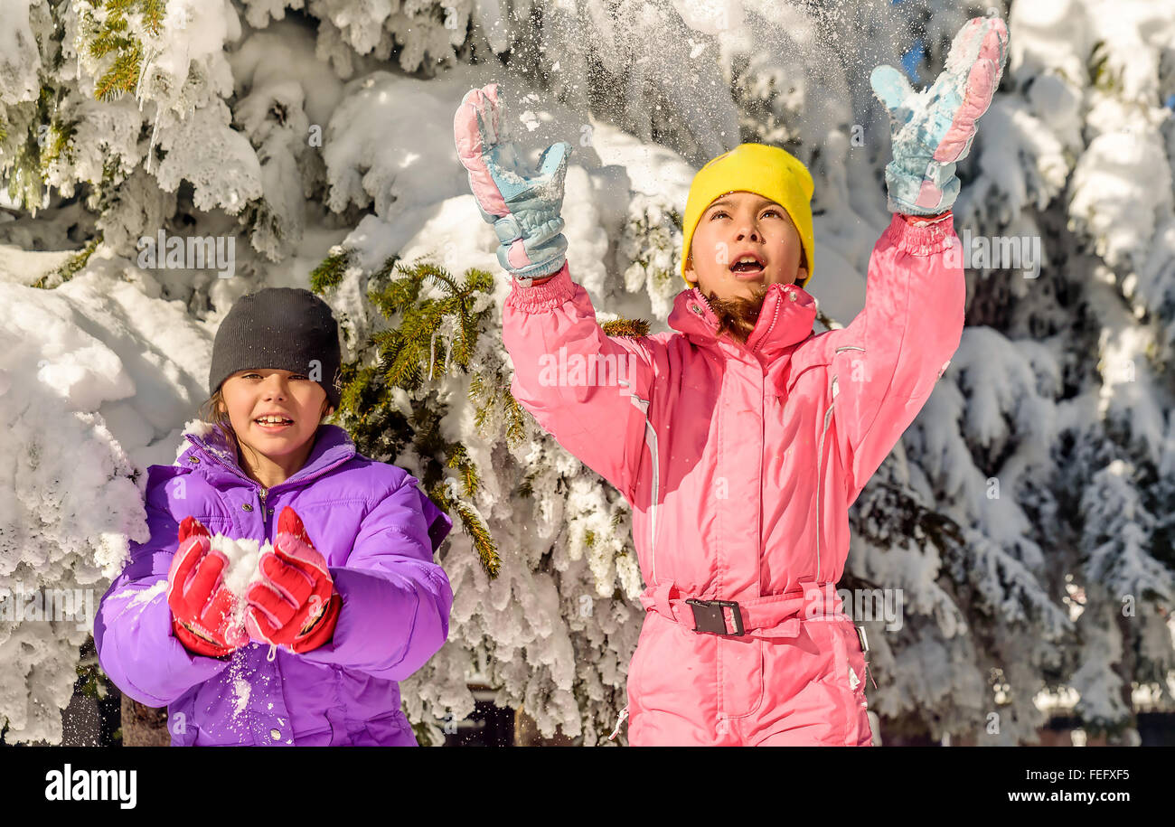 Two little girls are having fun in the snow Stock Photo - Alamy