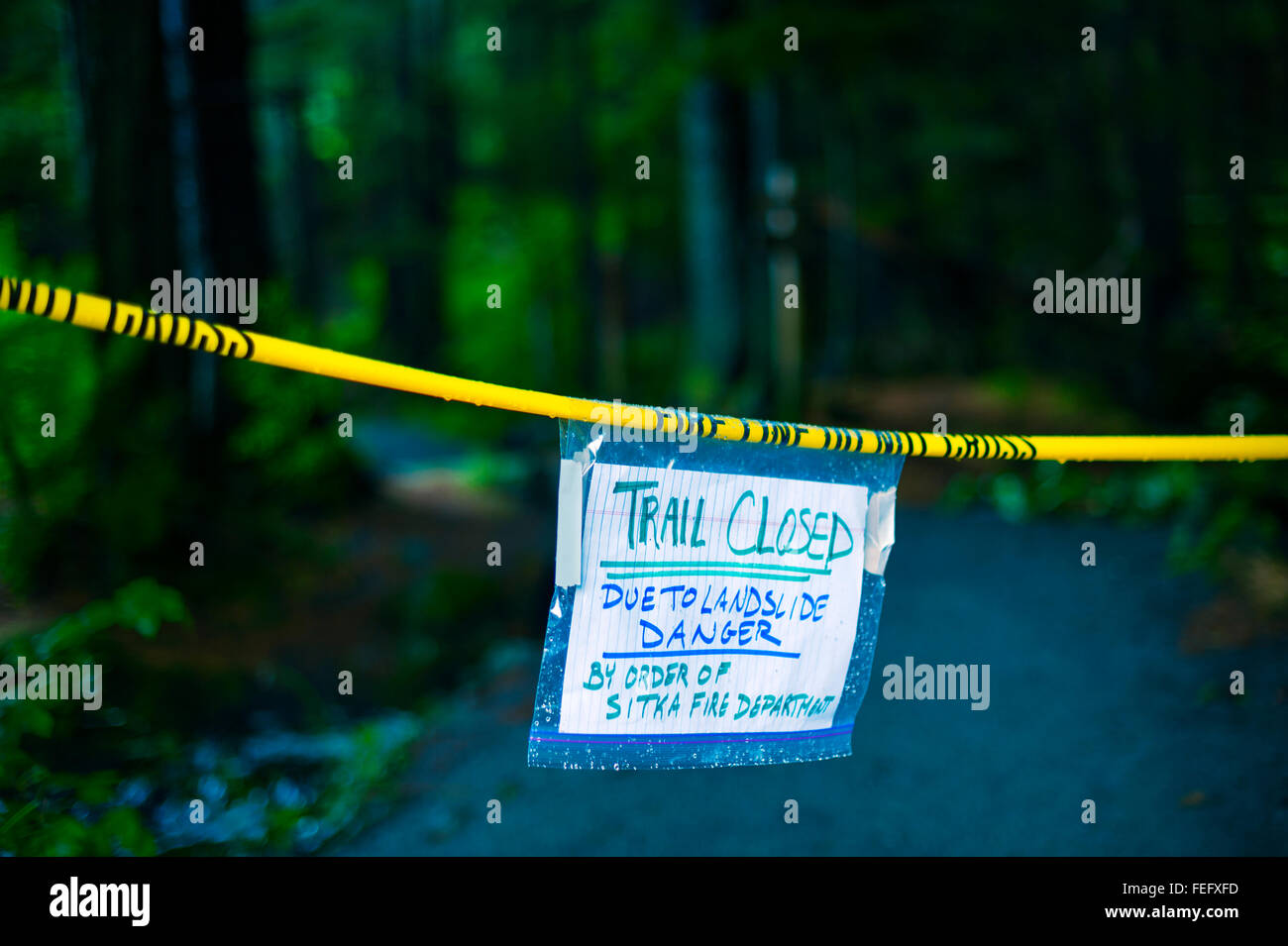 Sign strung across trail head warning, "Trail Closed due to land slide ...