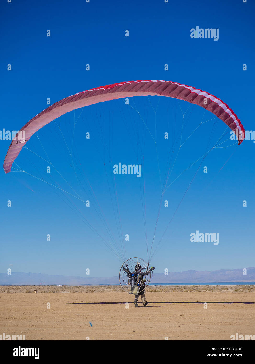 A paramotoring pilot gets ready for takeoff in his paramotor at a ...