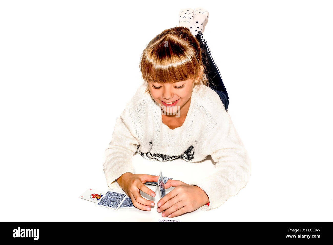Happy little girl making house of cards isolated on white Stock Photo ...