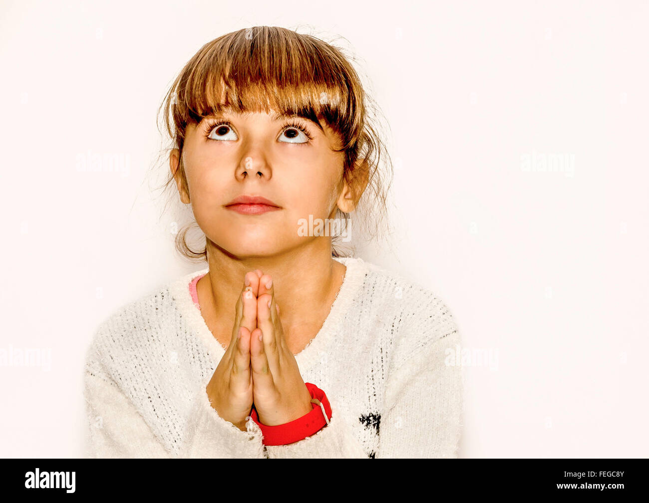 Beautiful little girl praying and looking up, isolated on white Stock ...