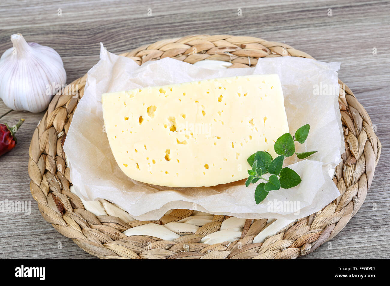 Part of round cheese on the wood background with herbs Stock Photo - Alamy