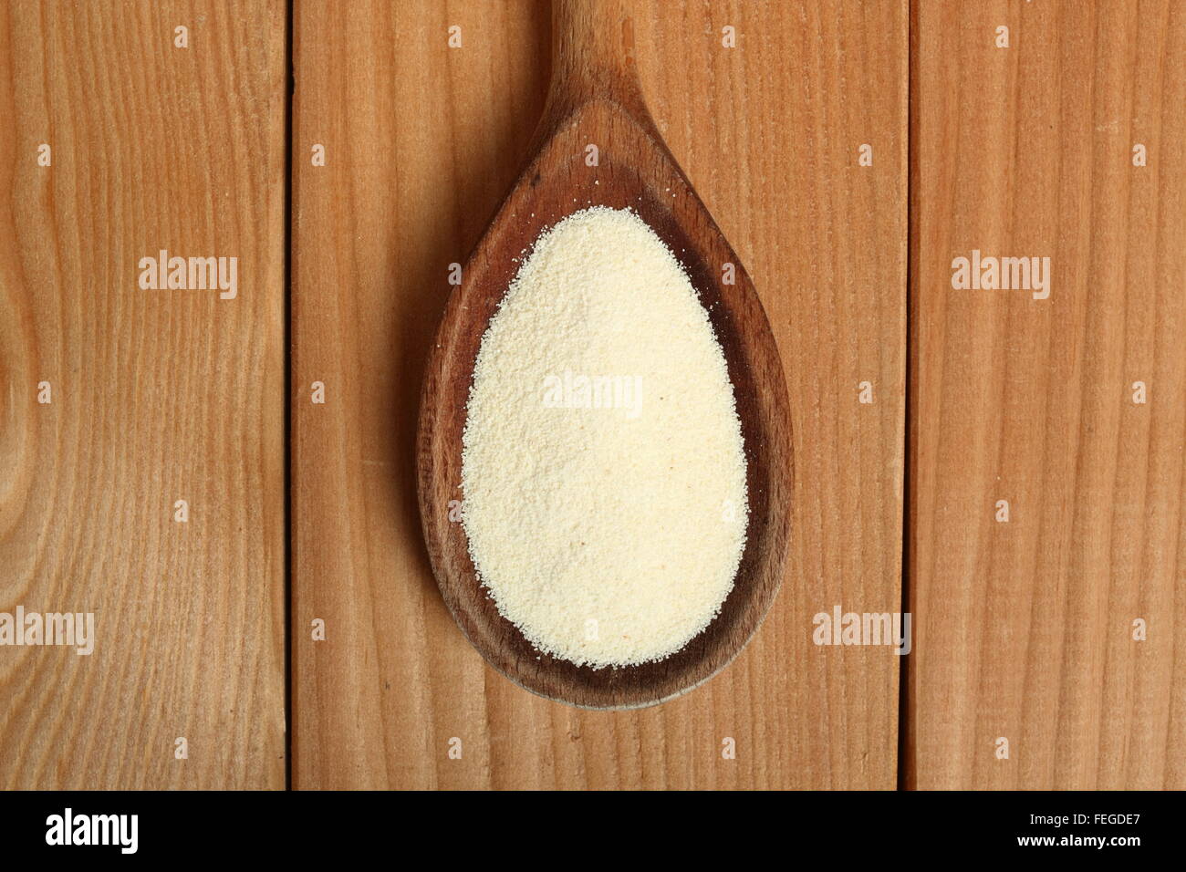 Farina (semolina) on wooden spoon at plank background. Directly Above ...