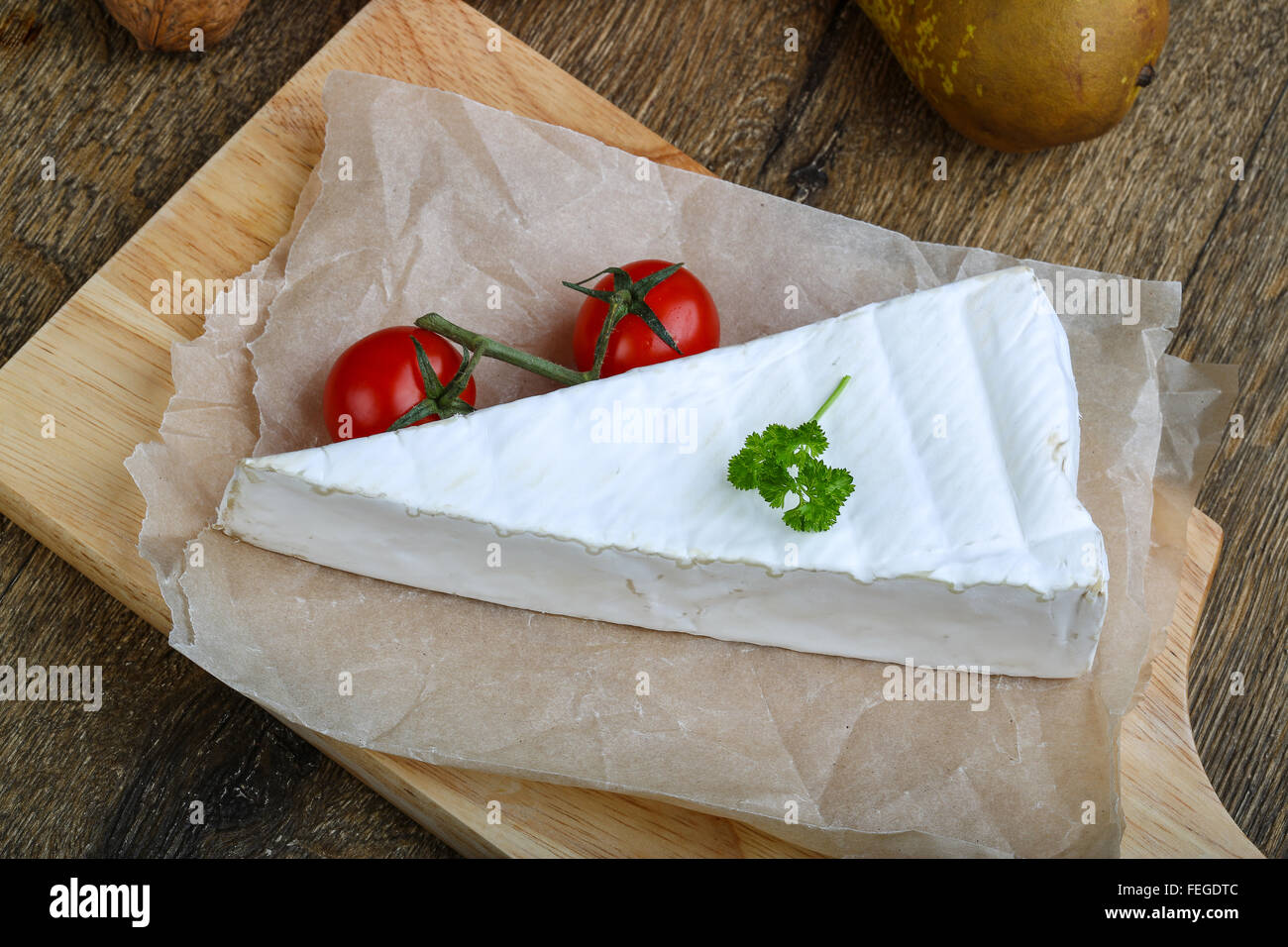 Brie cheese triangle with tomato and parsley Stock Photo - Alamy