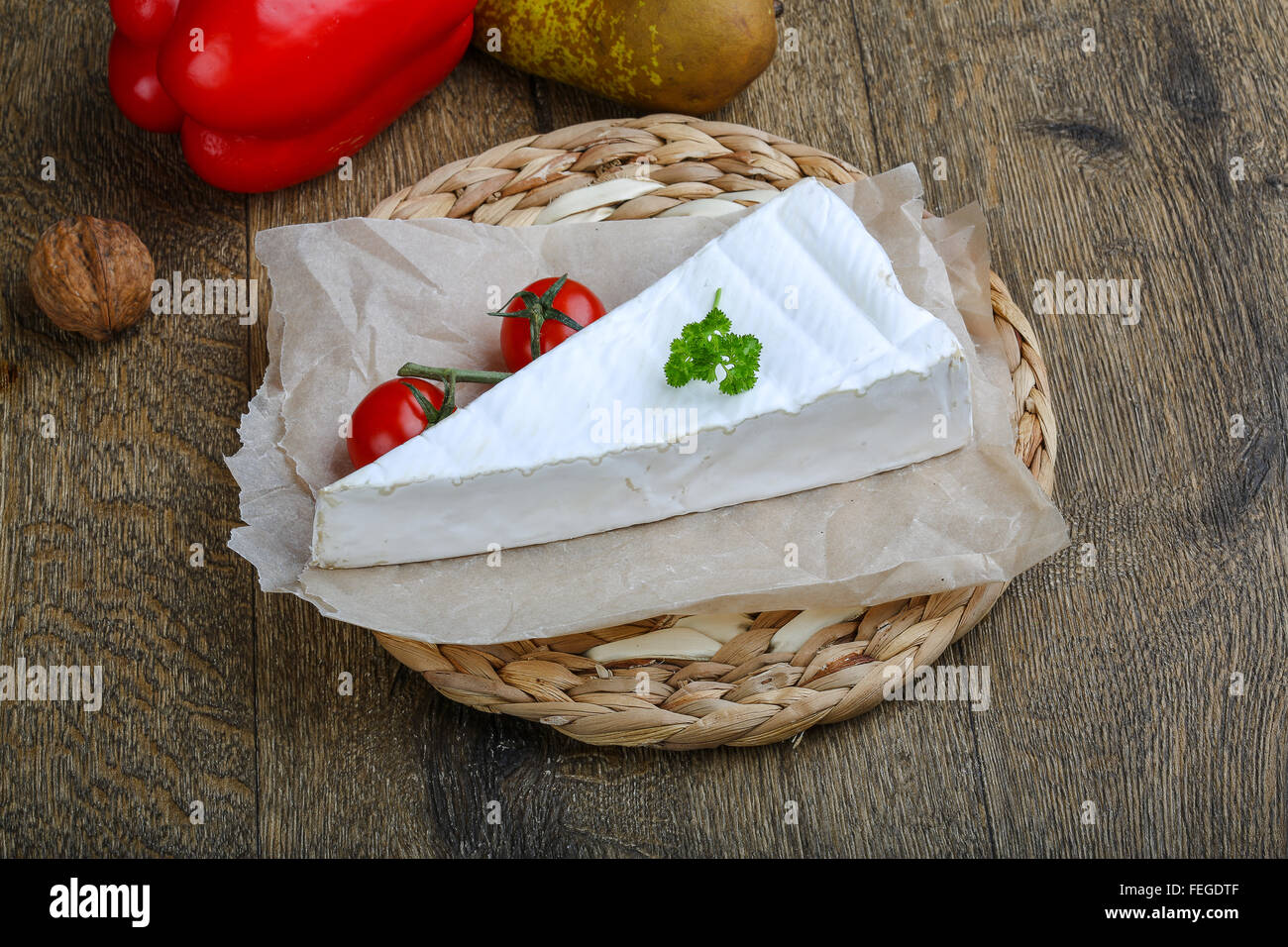 Brie cheese triangle with tomato and parsley Stock Photo - Alamy