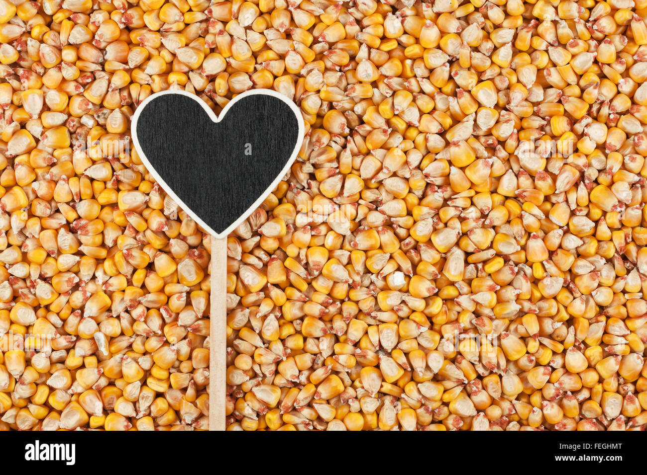 Pointer in the form of heart lies on corn grains, with space for your ...