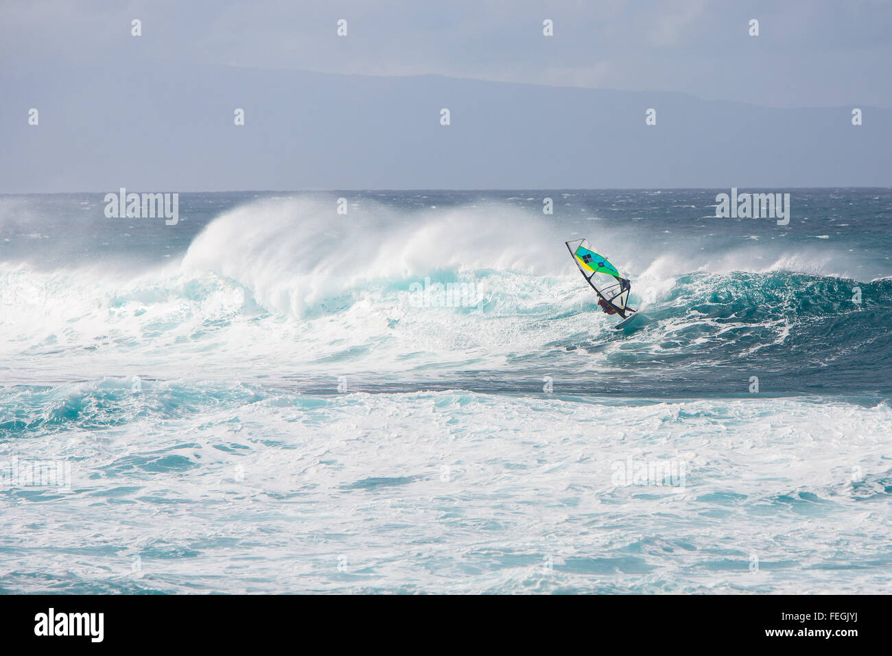 A windsurfer rides the waves in front of the Hoʻokipa beach on the ...