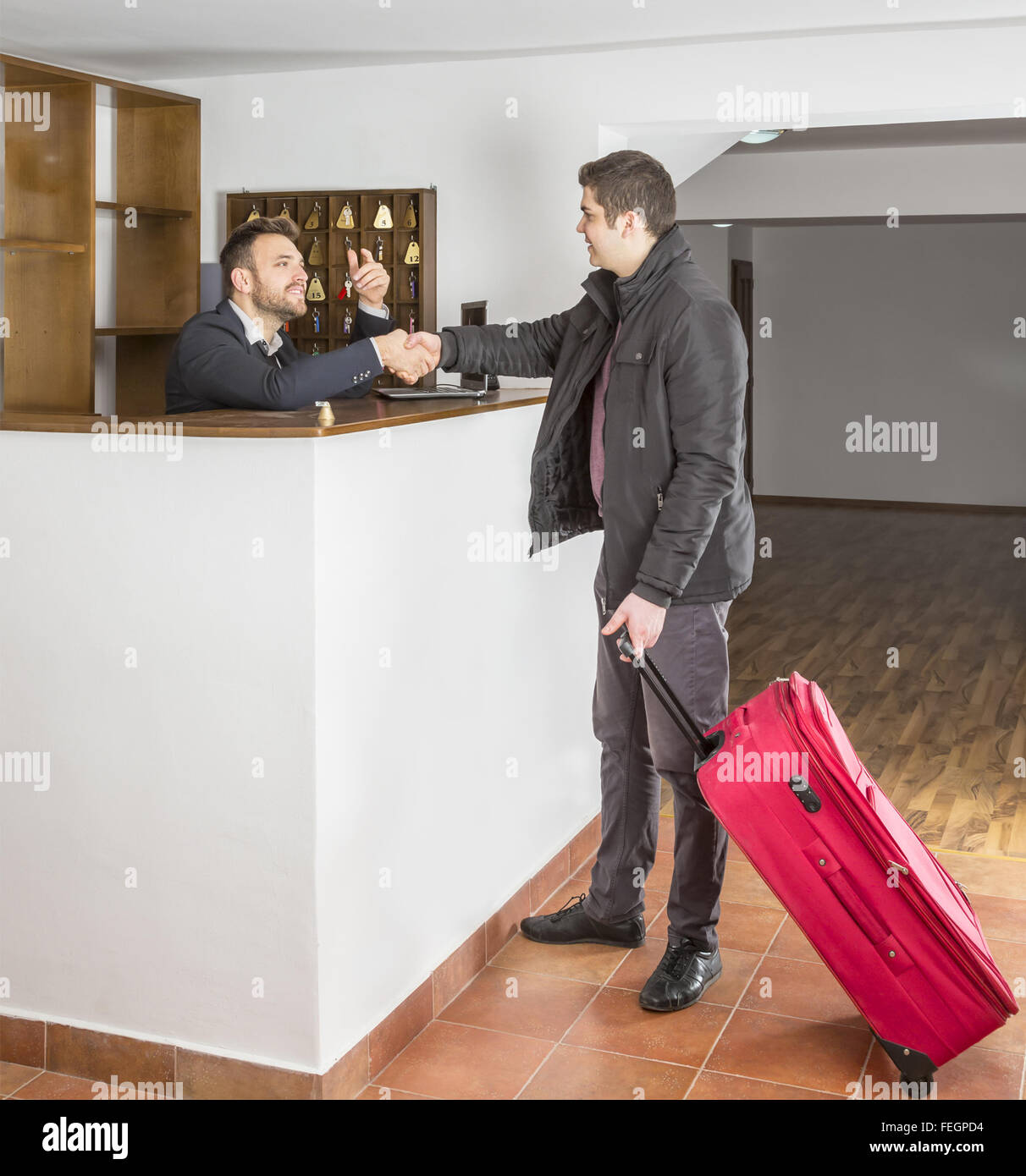 The receptionist and a client shaking hands at the hostel reception ...