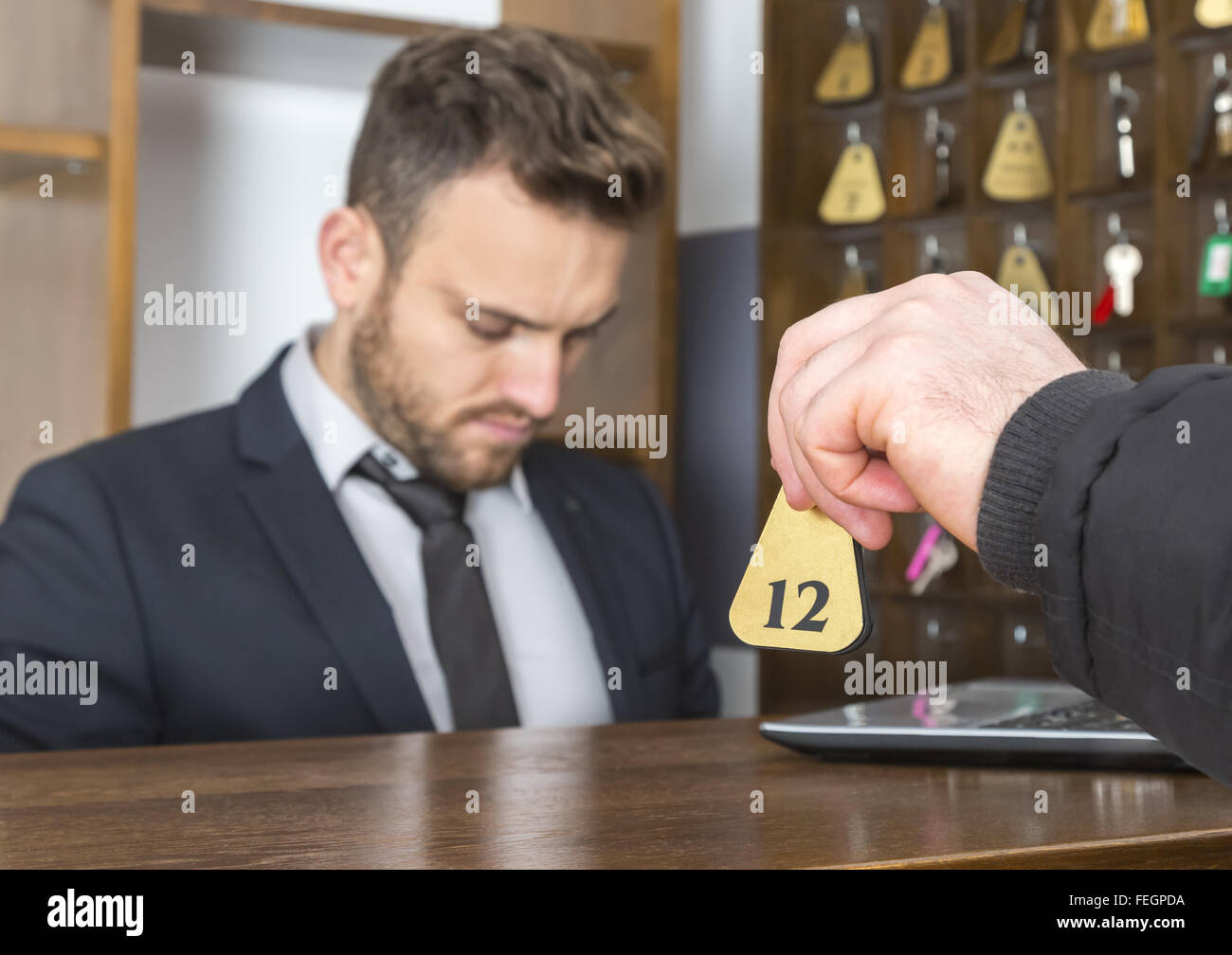 Image of a guest's hand giving the key at the hotel reception ...