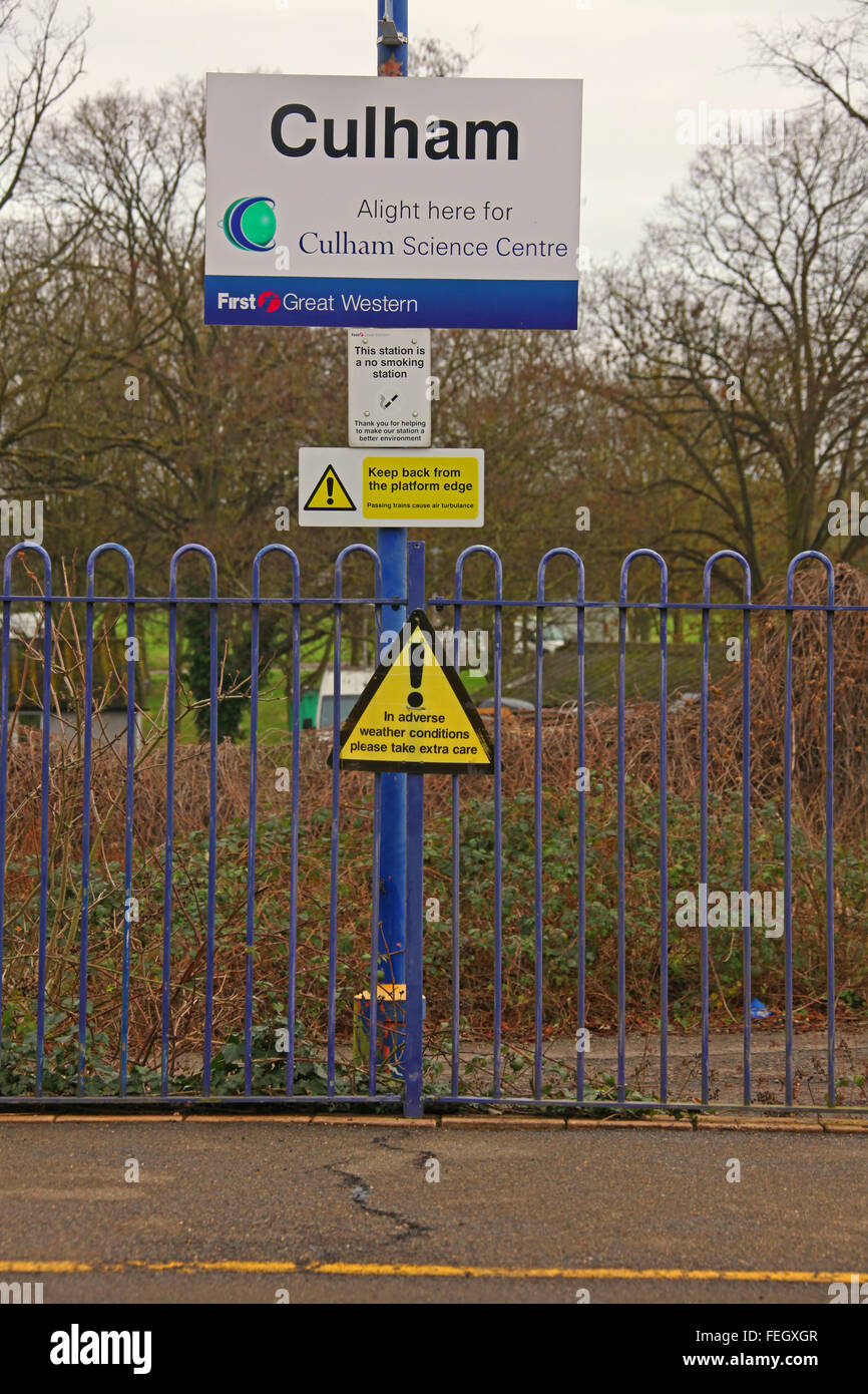 A series of signs mounted on a post adjacent to a platform stating ...