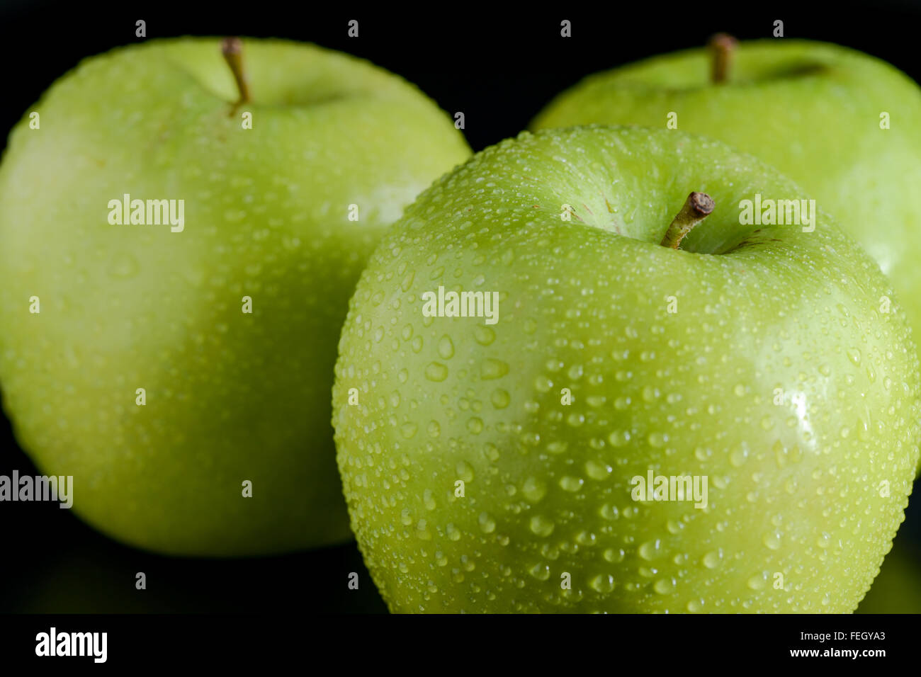 Green apple with droplets on black background Stock Photo - Alamy