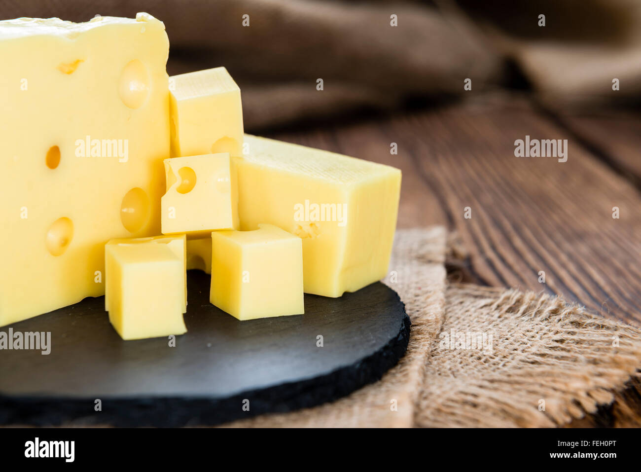 Diced Cheese (close-up shot) on rustic wooden background Stock Photo ...