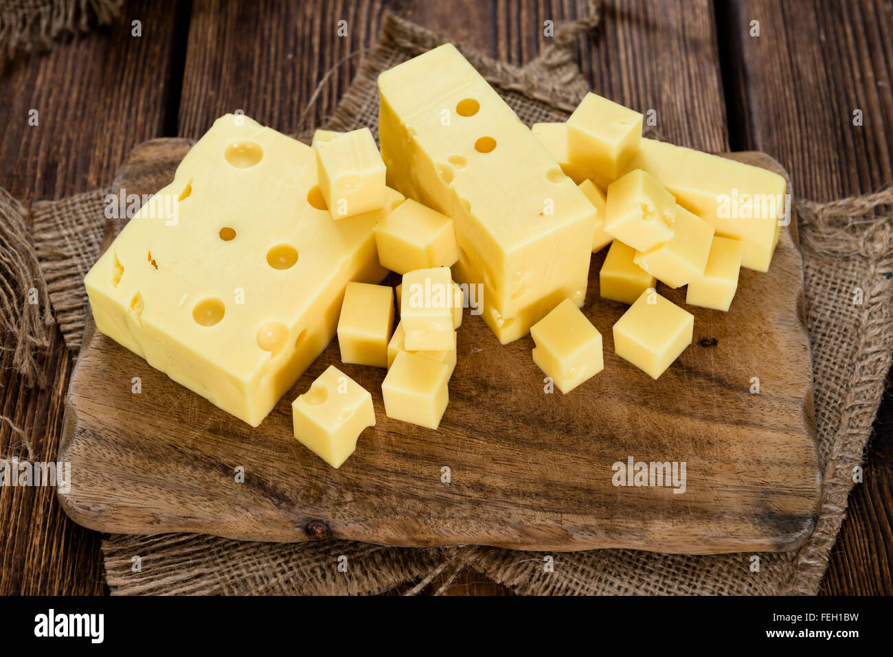 Diced Cheese (close-up shot) on rustic wooden background Stock Photo ...