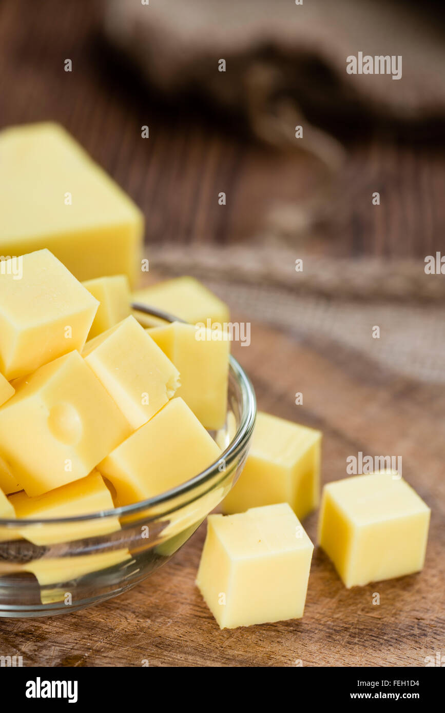 Diced Cheese (close-up shot) on rustic wooden background Stock Photo ...
