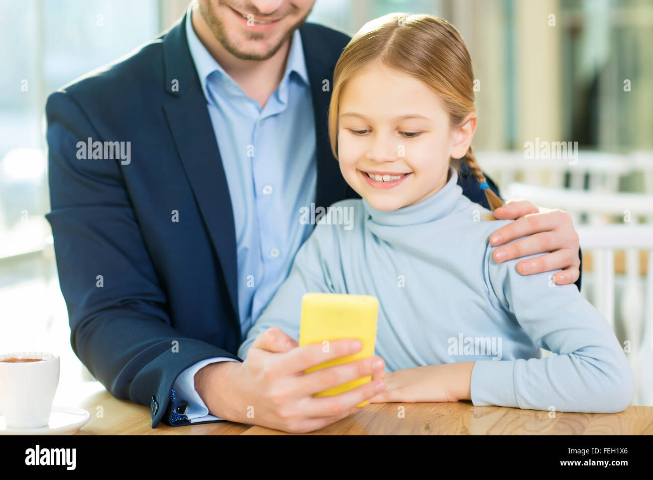 Young loving father showing adorable daughter how to use smartphone ...