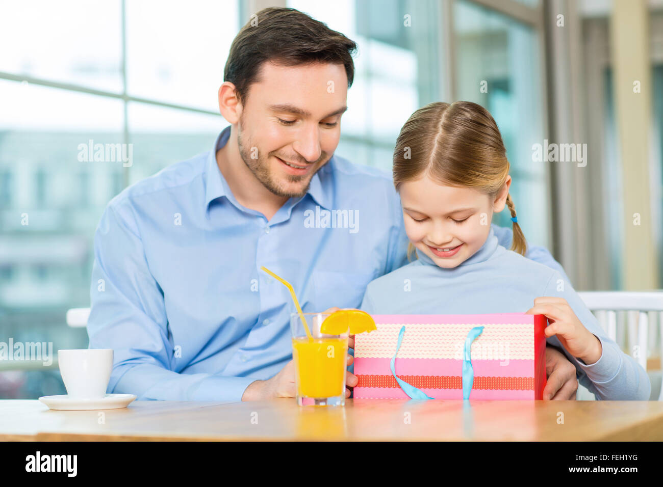 Young father and cute daughter staring at the present Stock Photo - Alamy