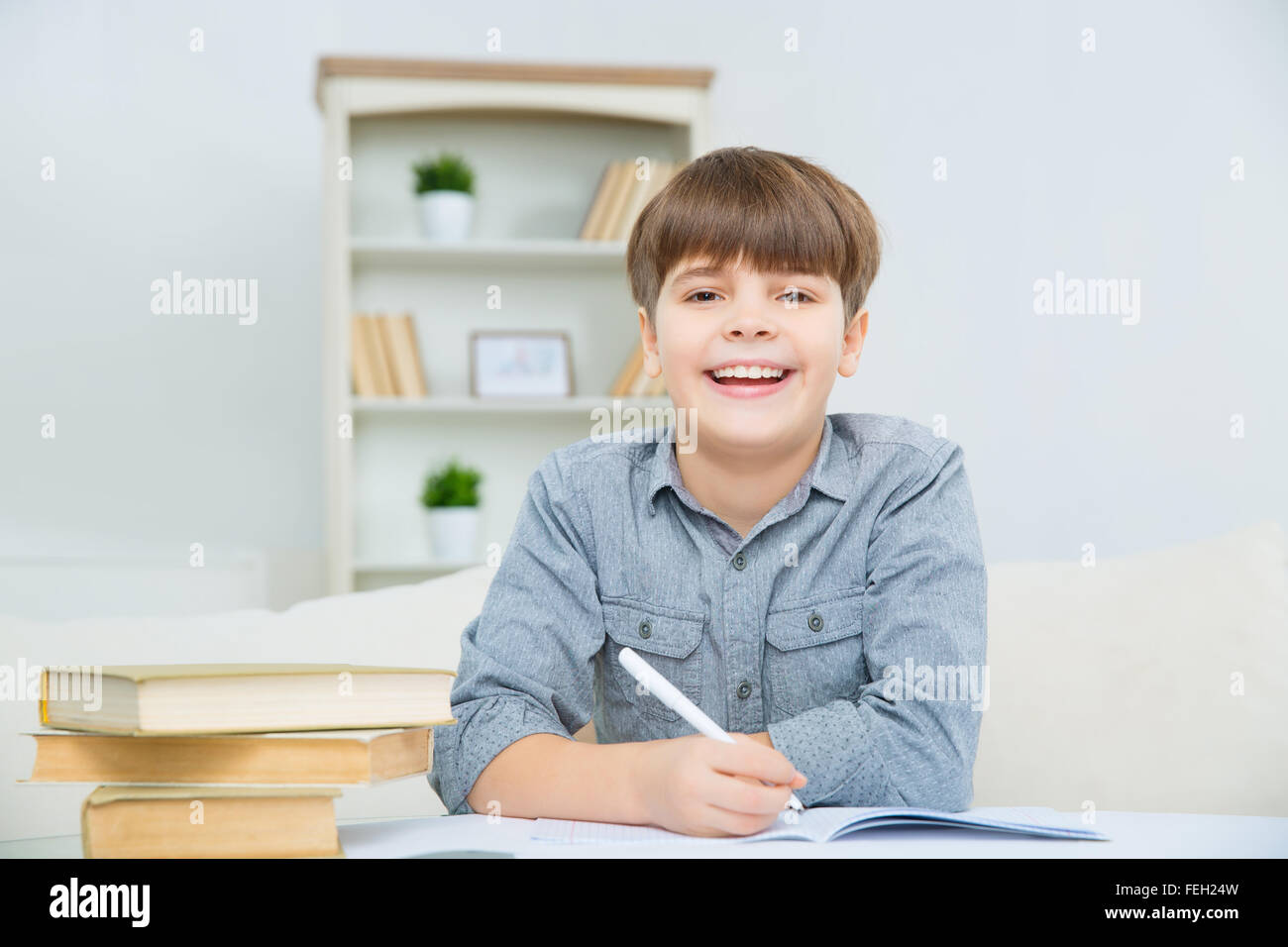 Beautiful happy child smiling while doing homework Stock Photo - Alamy