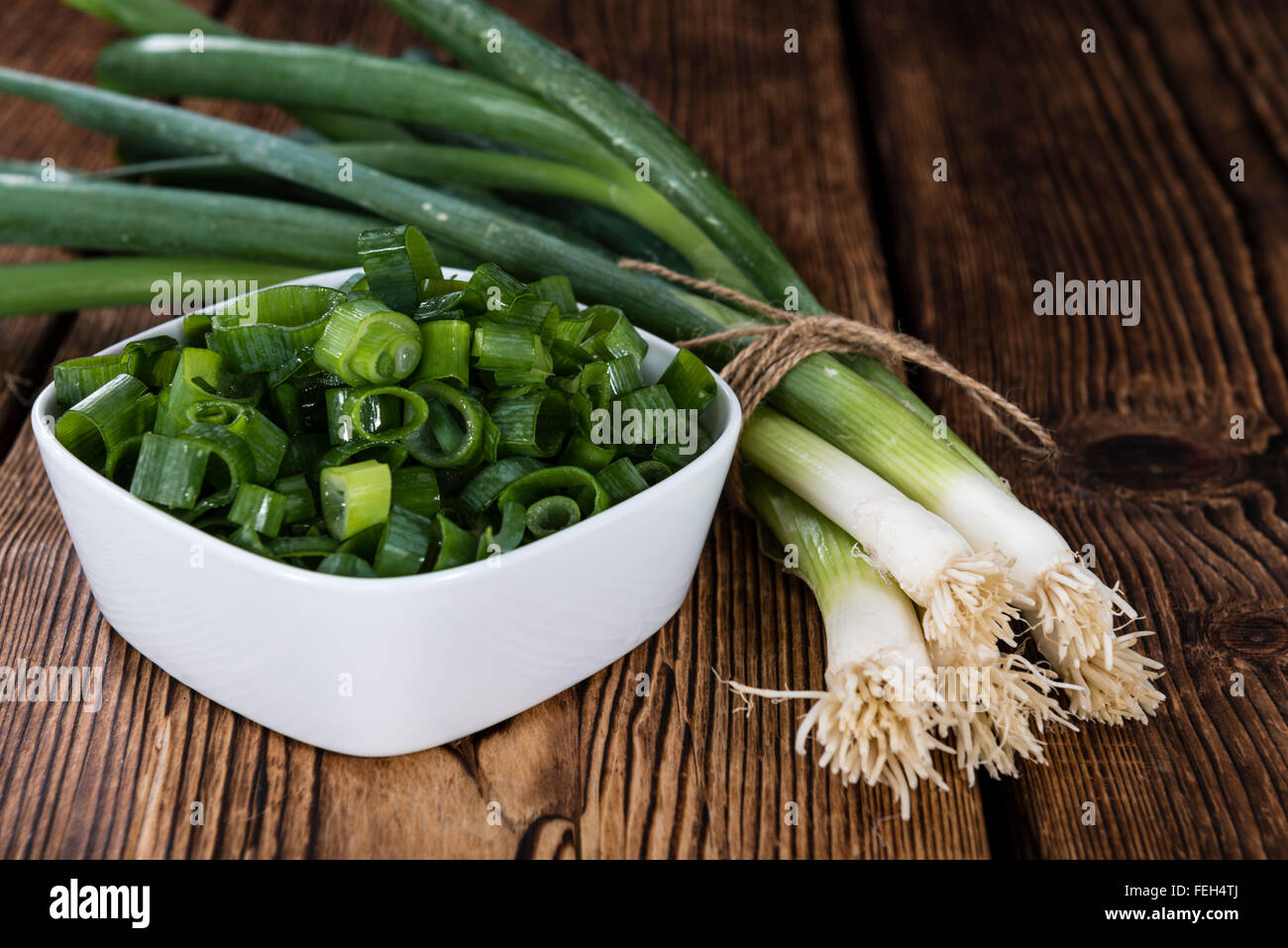 Portion of fresh Scallions (detailed close-up shot) on vintage wooden ...