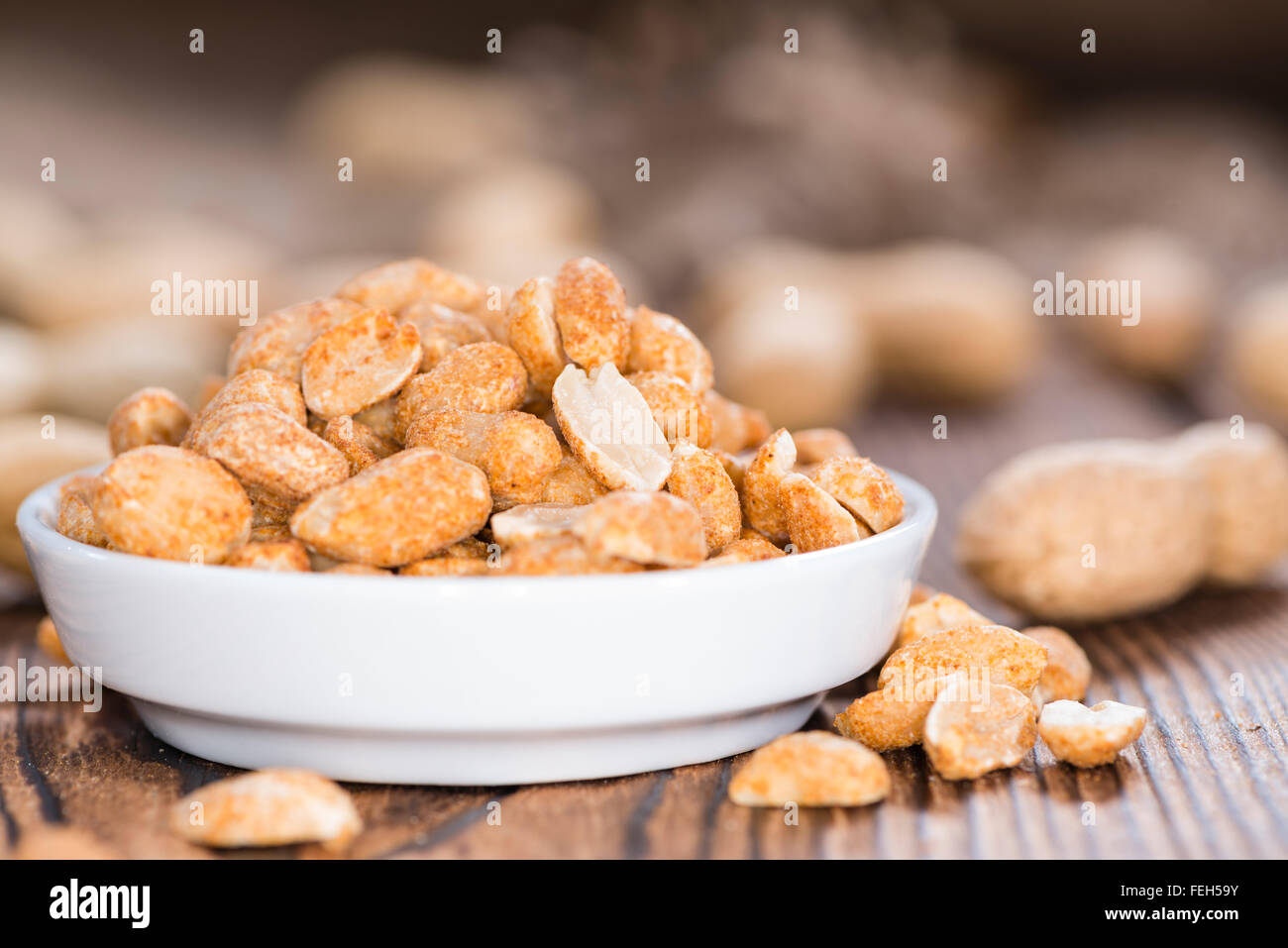 Roasted Peanuts with spices and salt (close-up shot) on dark wooden ...