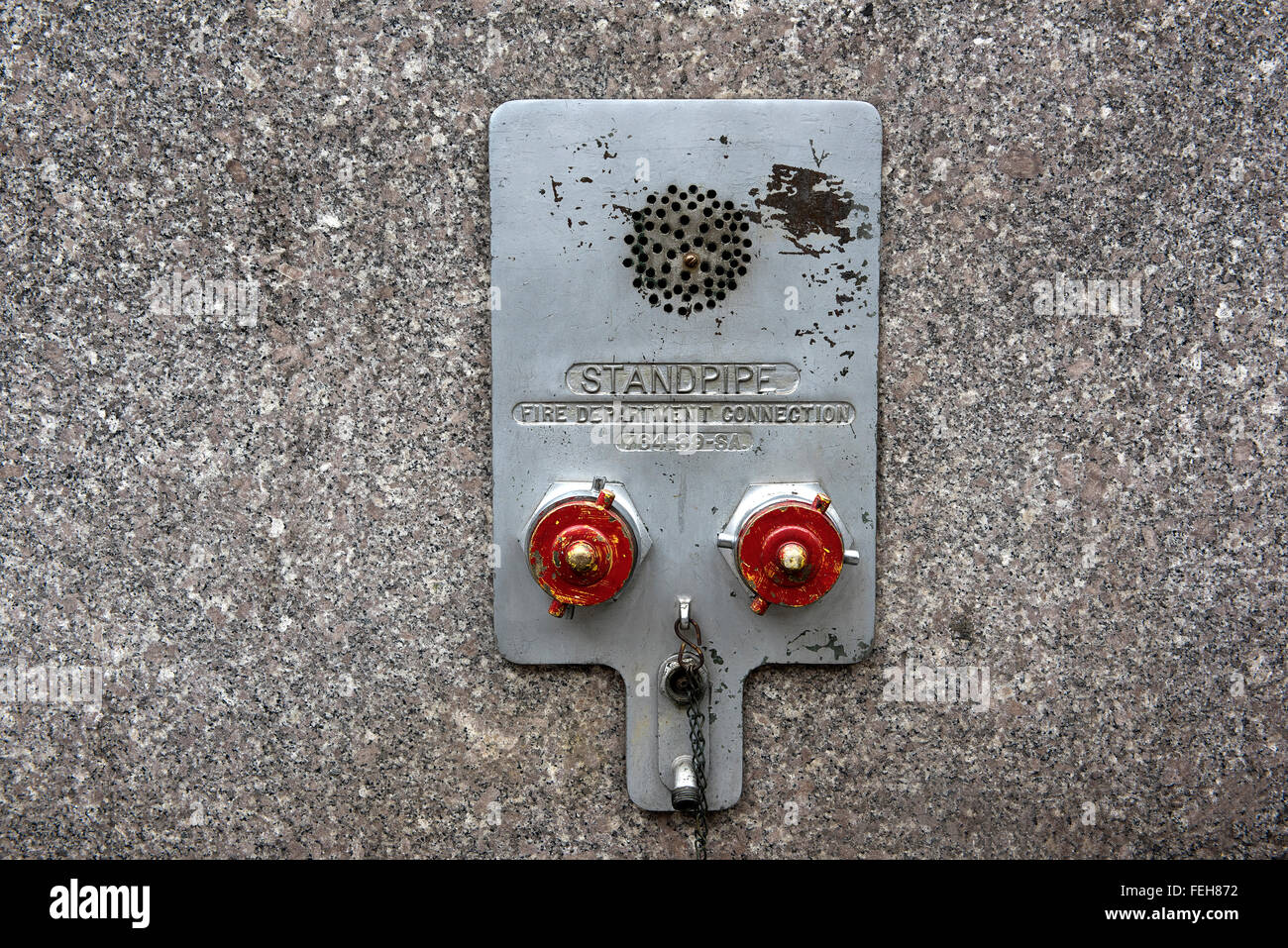 Metal fire department standpipe connections with red covers on granite ...