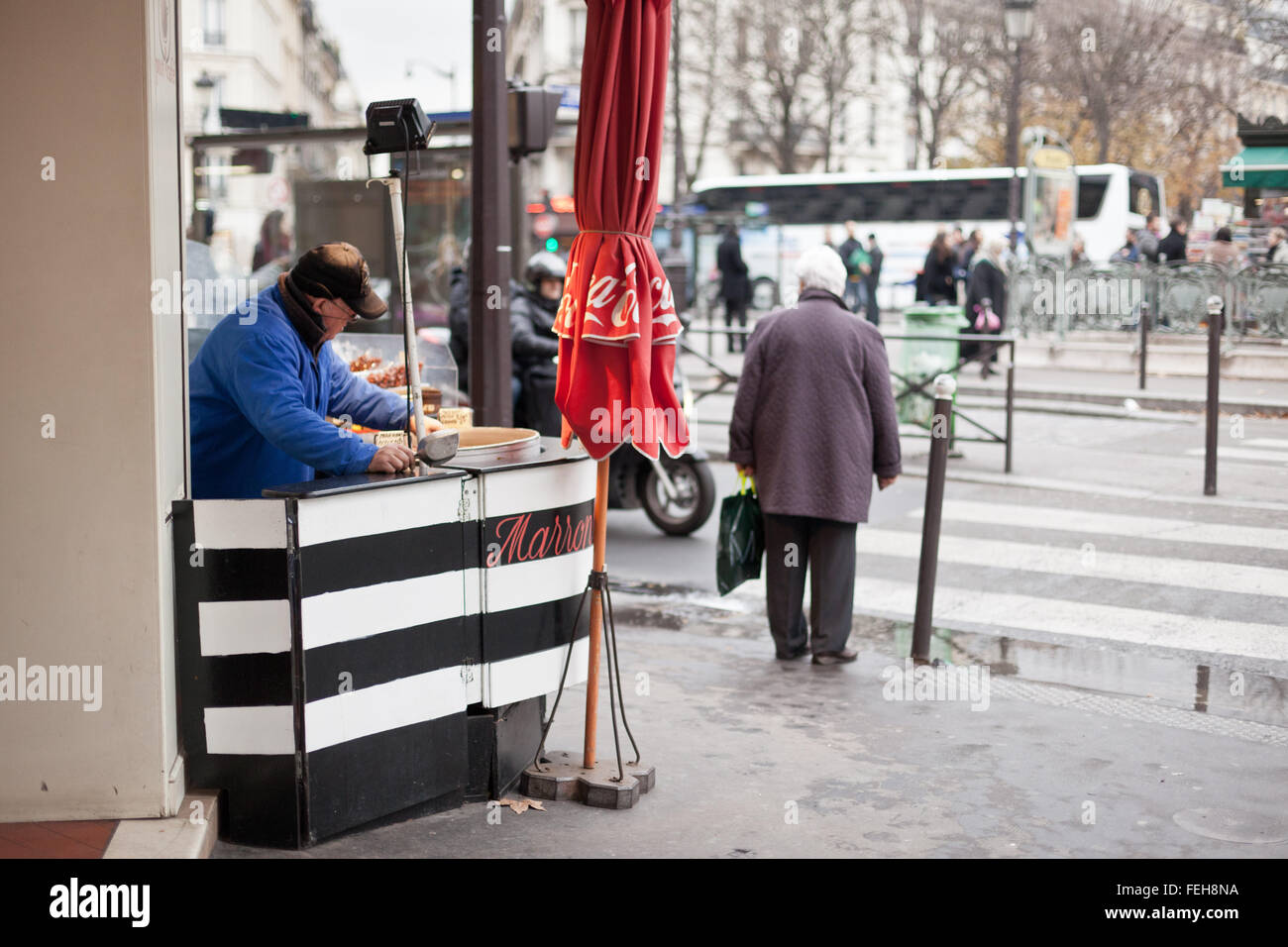 Man making crepes at stall on Paris street corner, woman waits to cross ...