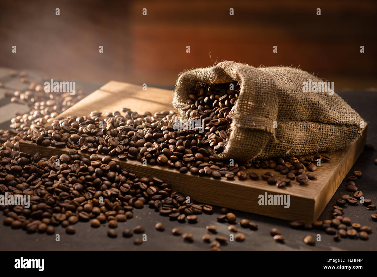 spilled coffee beans in bag on wood Stock Photo - Alamy