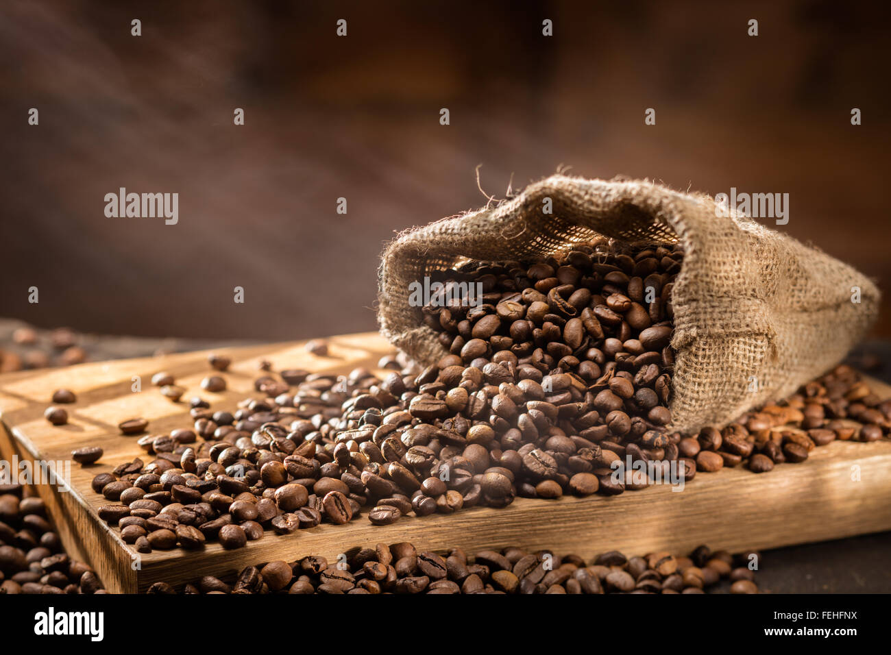 spilled coffee beans in bag on wood Stock Photo - Alamy