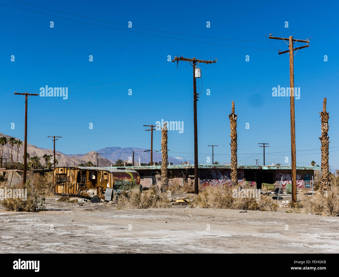 Deserted ruins of a graffiti tagged building and dilapidated trailer in ...