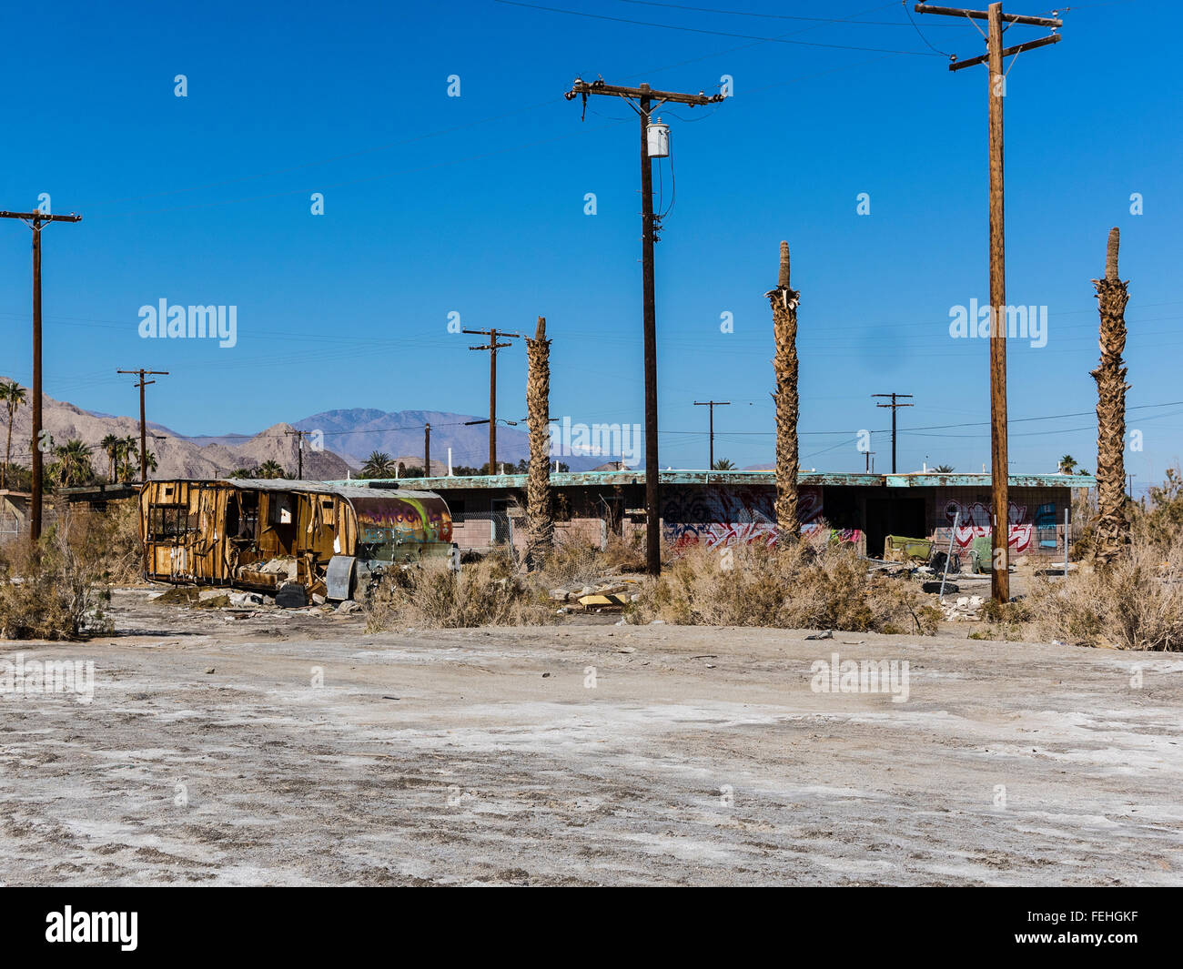 Deserted ruins of a graffiti tagged building and dilapidated trailer in ...
