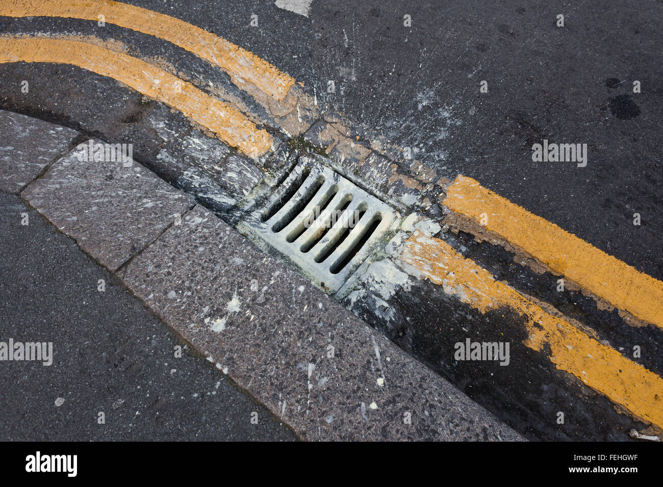 Drain on road with paint splatter, and double yellow lines to each side ...