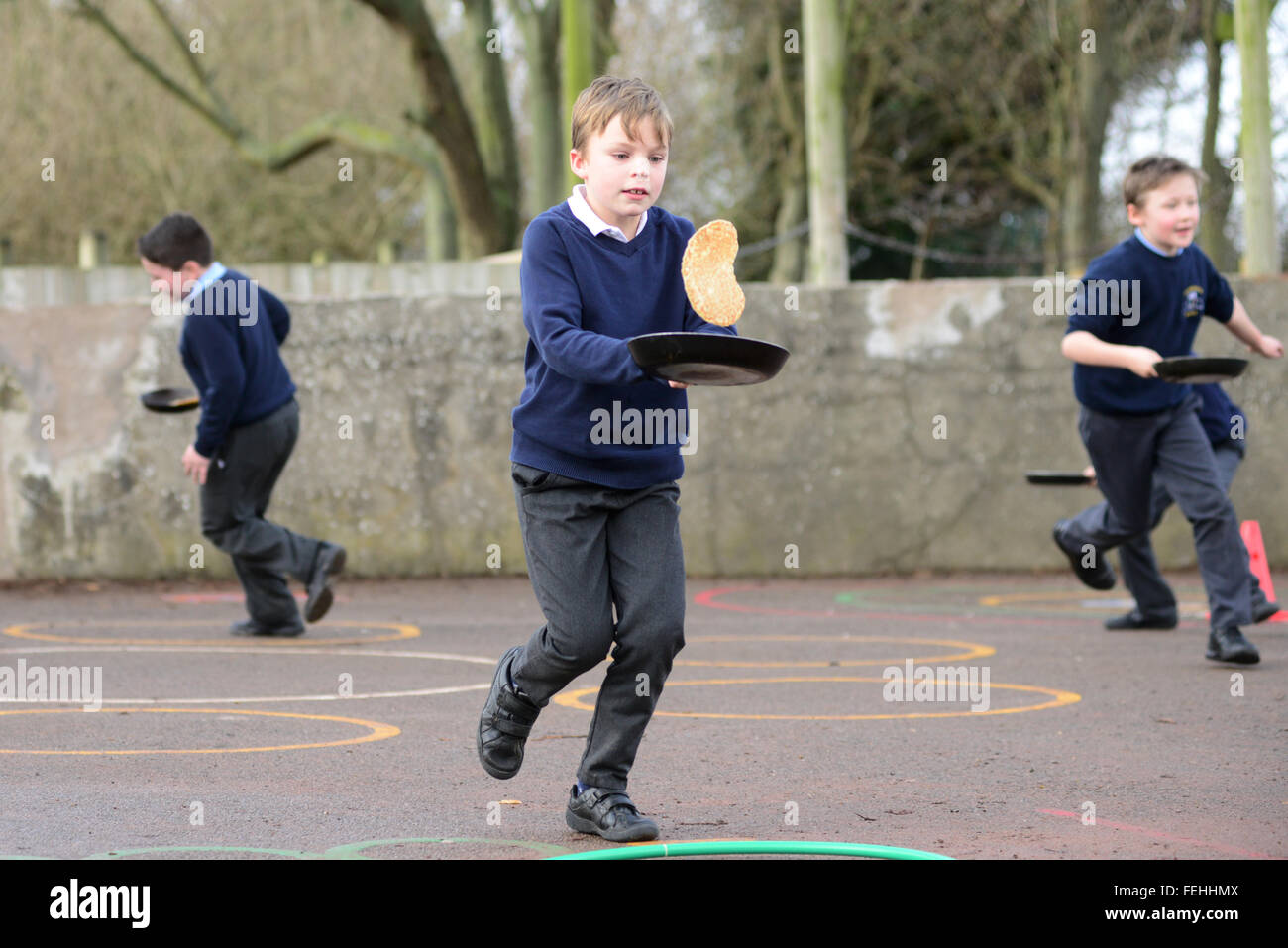 School children enjoying a pancake race Stock Photo - Alamy
