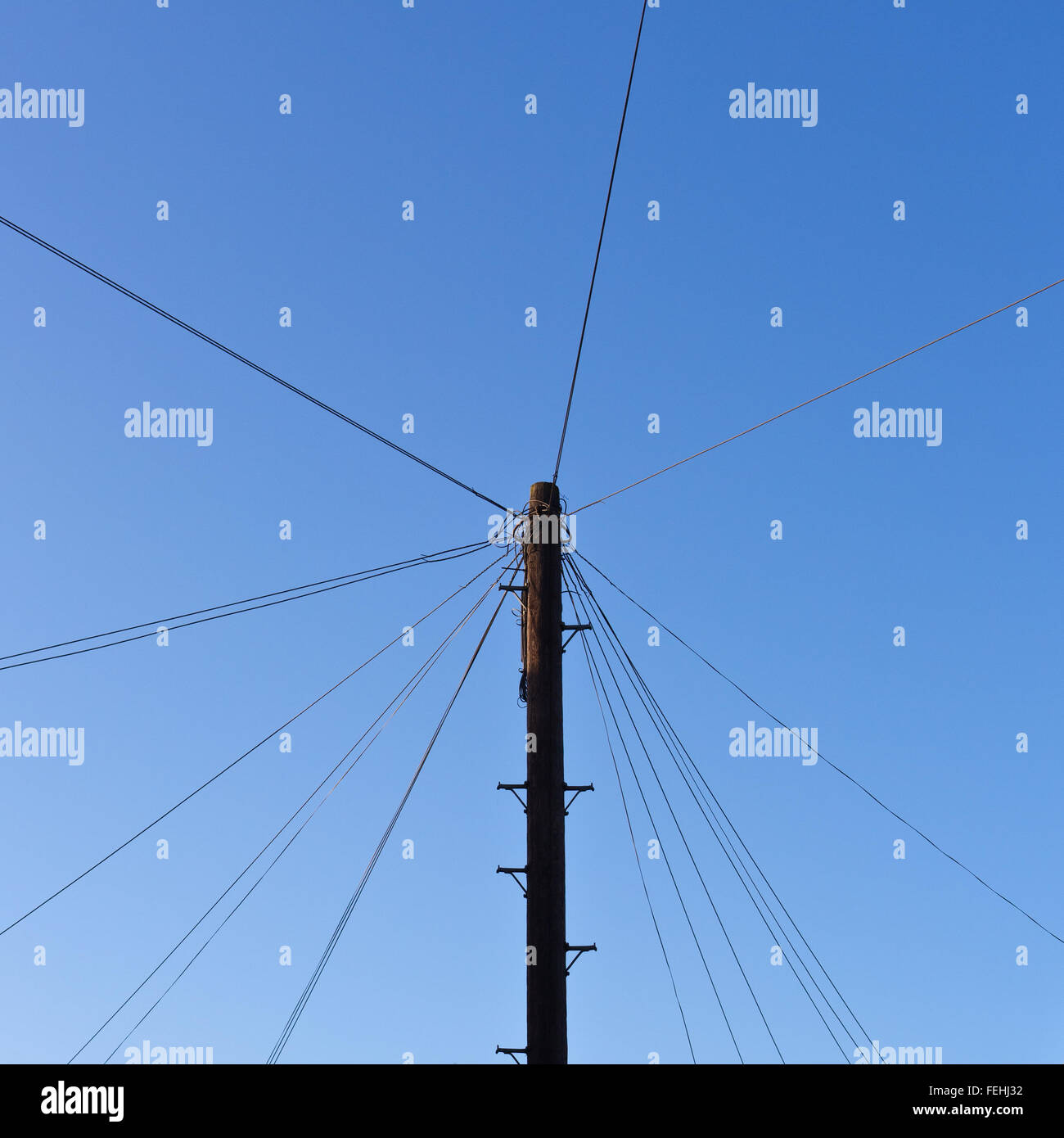 Telegraph pole and lines in front of blue sky Stock Photo - Alamy
