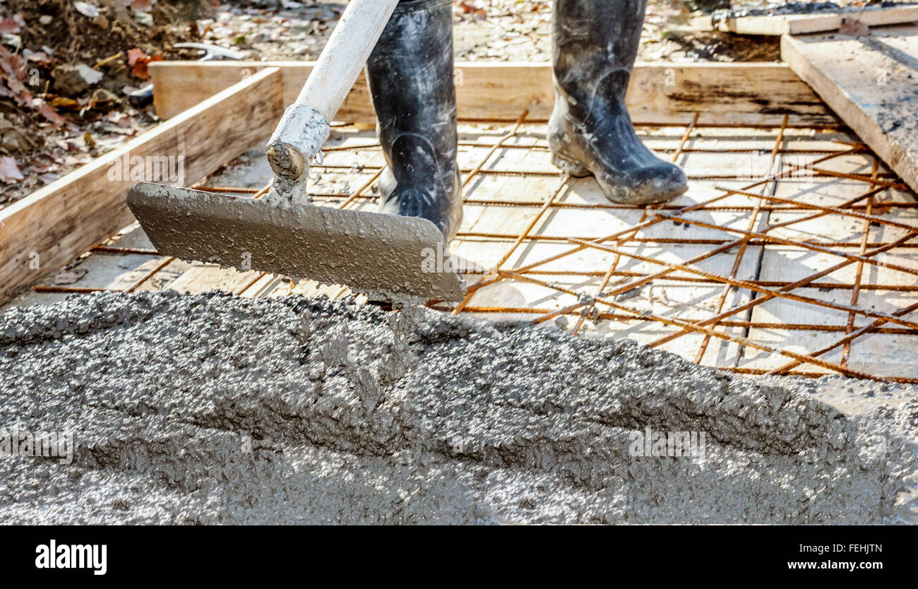 Worker with gum boots spreading ready mix concrete Stock Photo - Alamy