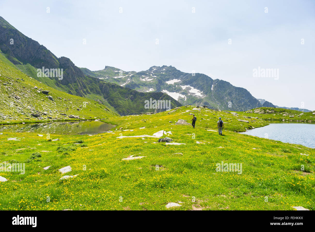 Two people hiking uphill on footpath in the italian Alps. Summer ...