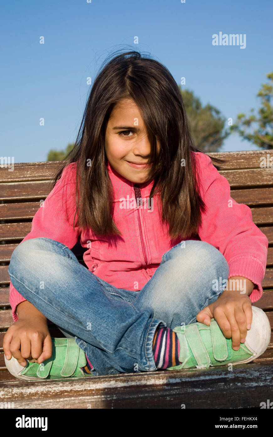 Little girl sitting on bench Stock Photo - Alamy