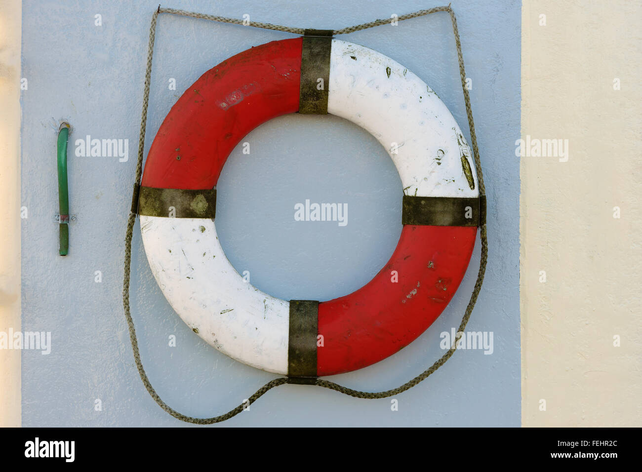 An old and weathered life buoy hang on the outside of a ship beside a ...