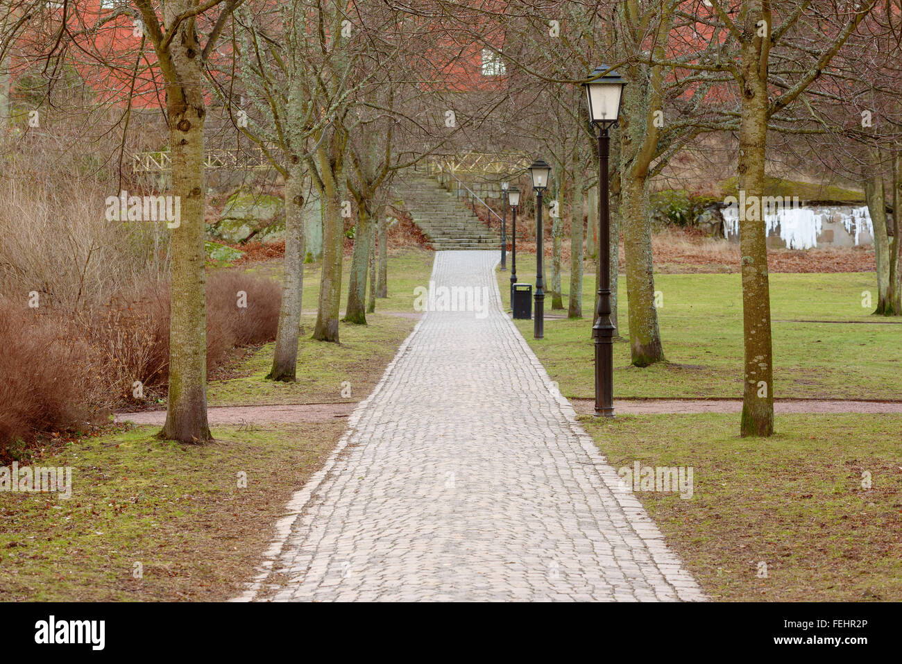 A straight walkway made of granite stone leads to a staircase up to a ...