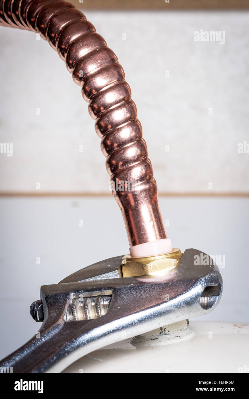 Wrench tightens a copper pipe Stock Photo - Alamy