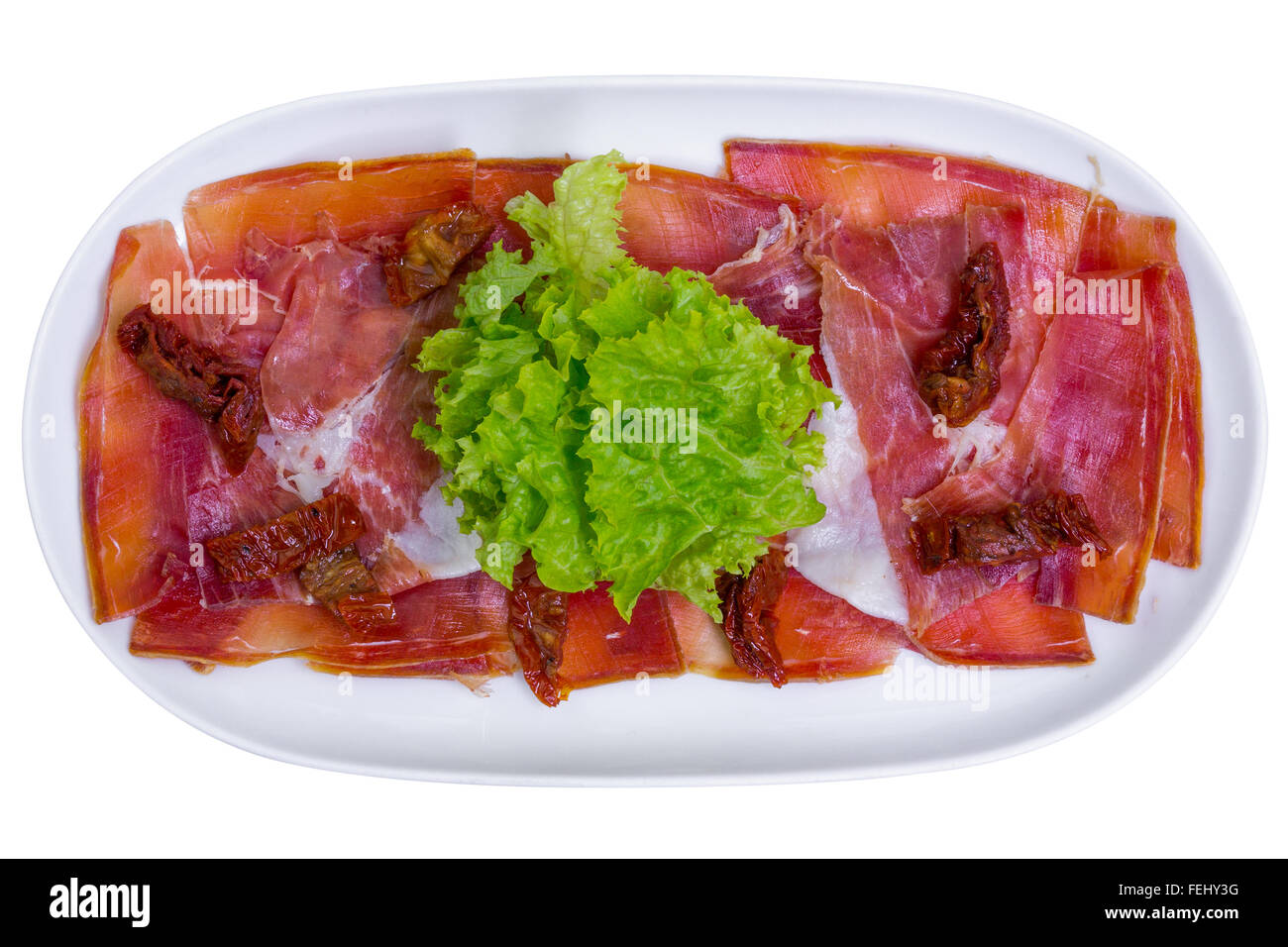 Traditional Spanish ham (jamon) in white plate, top view, isolated ...