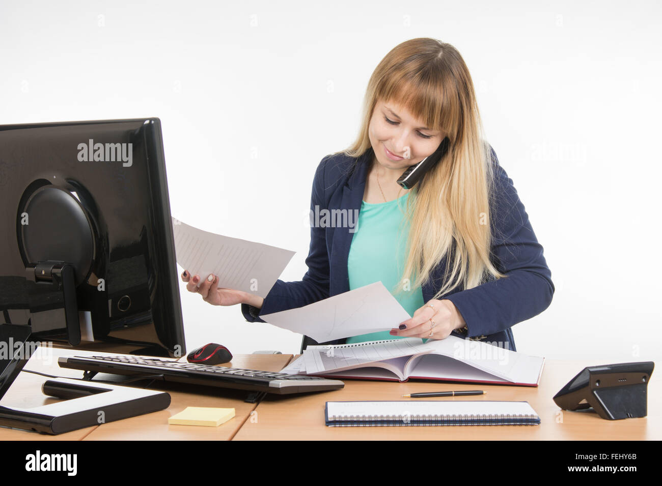 Young woman secretary sitting at office desk working, isolated on white ...