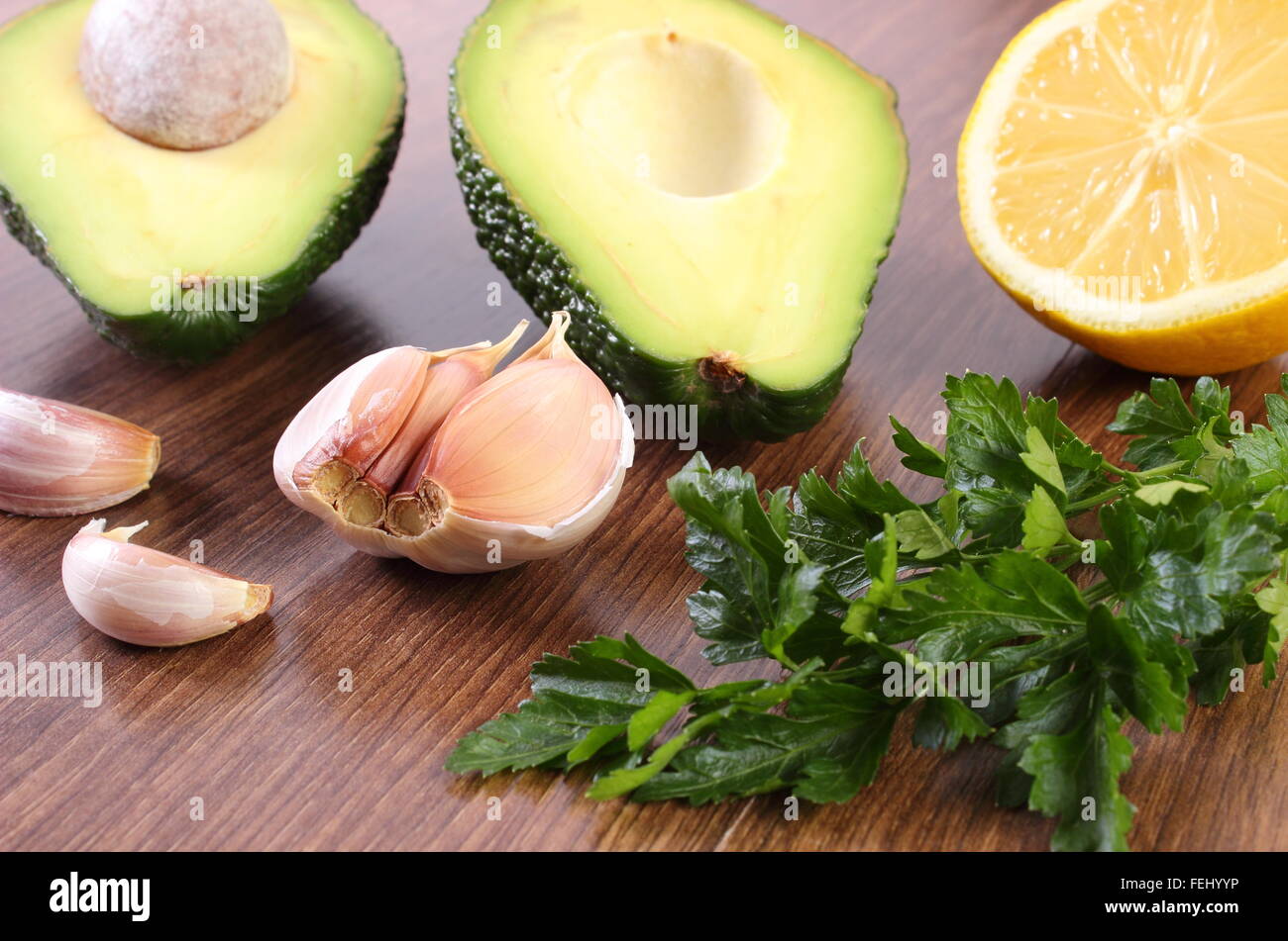 Portion of avocado, clove garlic, lemon and parsley, concept of healthy ...