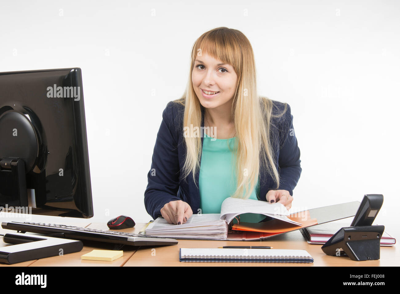 Young woman secretary sitting at office desk working, isolated on white ...