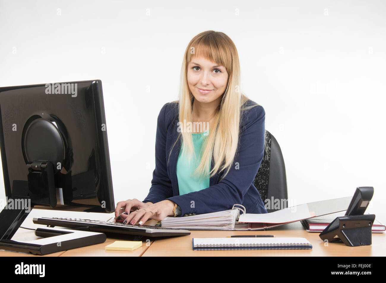 Young woman secretary sitting at office desk working, isolated on white ...