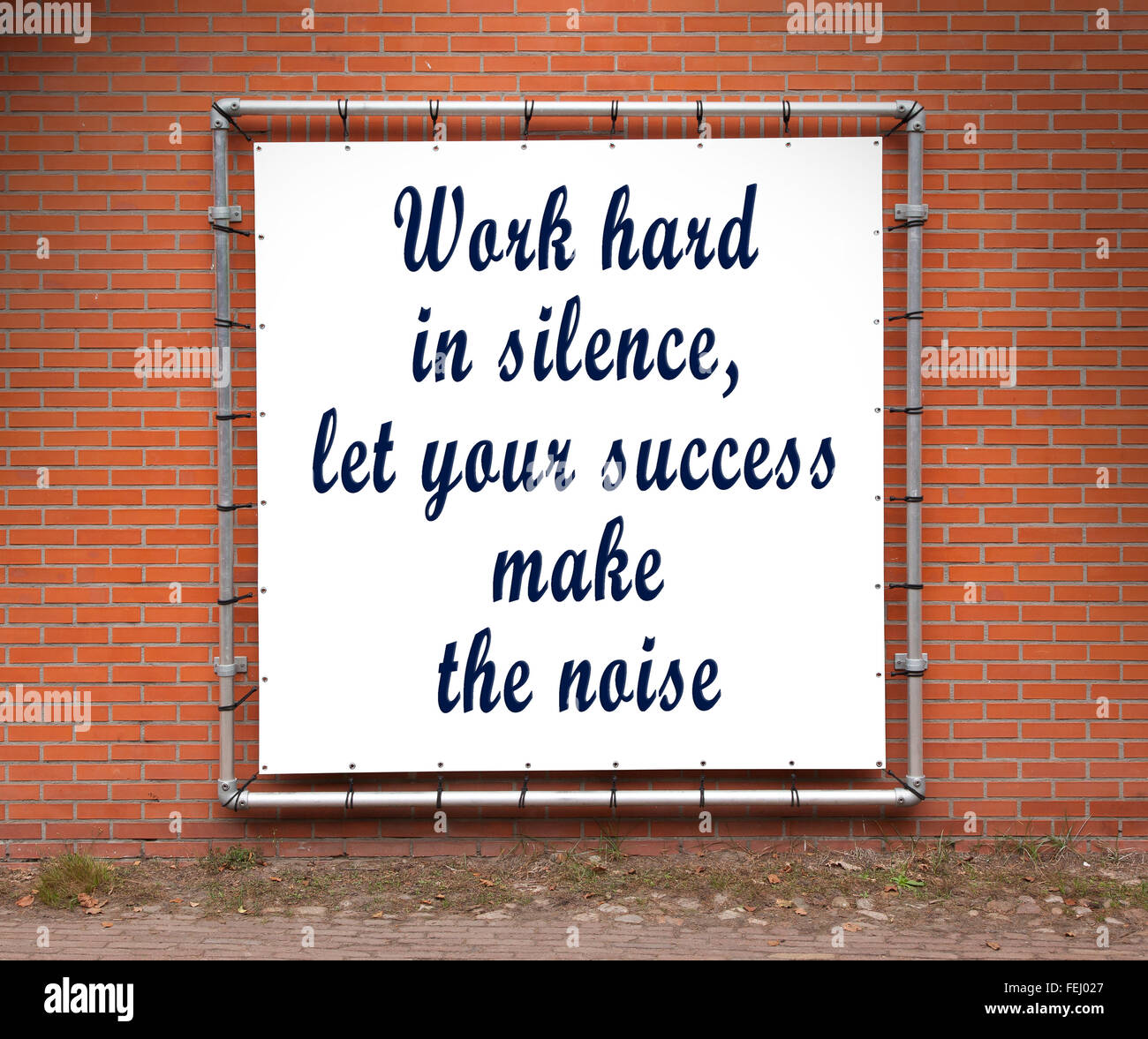 Large banner with inspirational quote on a brick wall - Work hard in ...