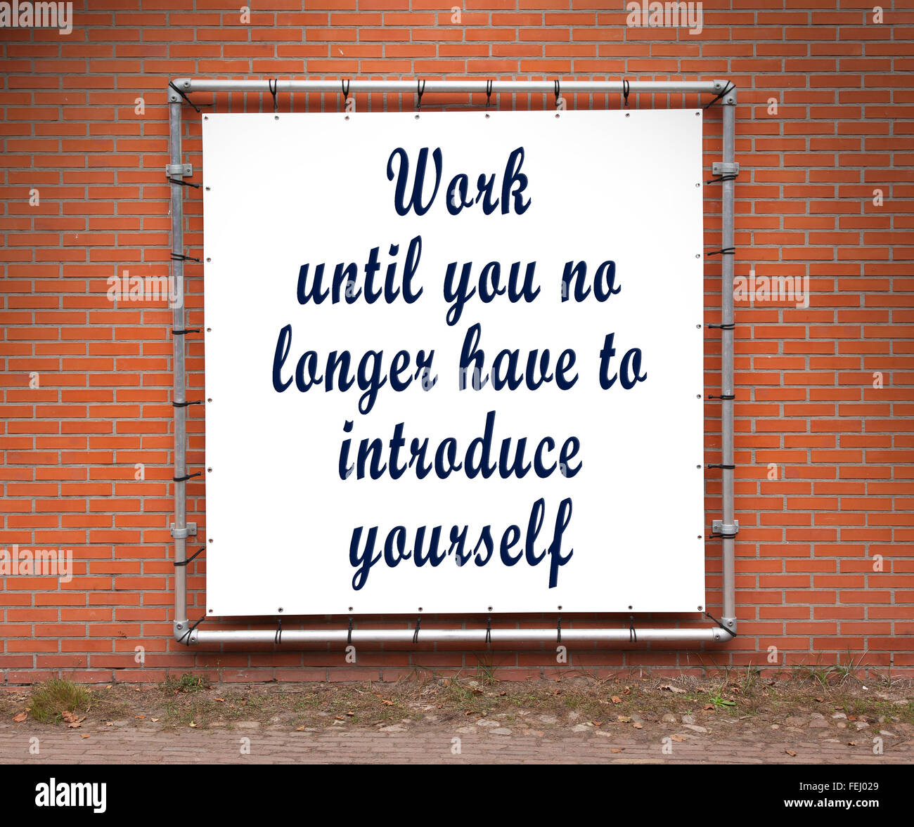 Large banner with inspirational quote on a brick wall - Work until you ...
